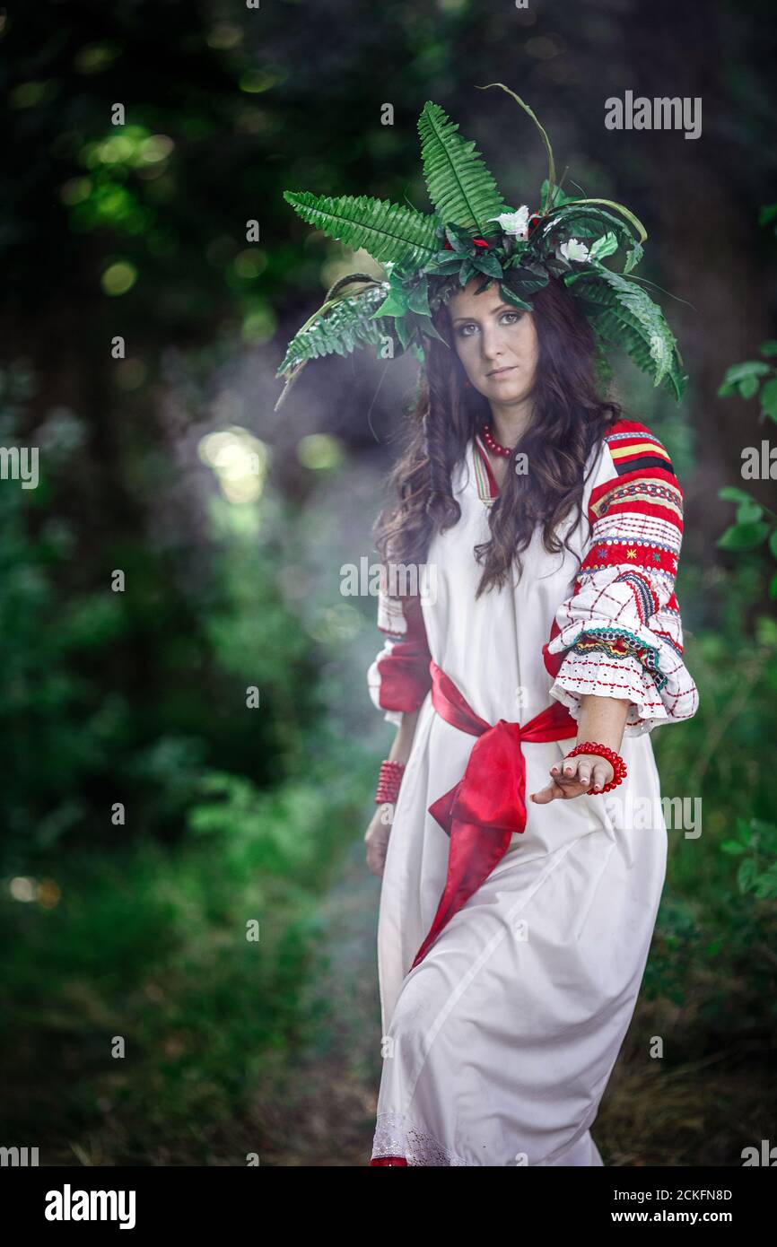 beautiful woman in wreath of wild flowers of flowers in sunny day ...