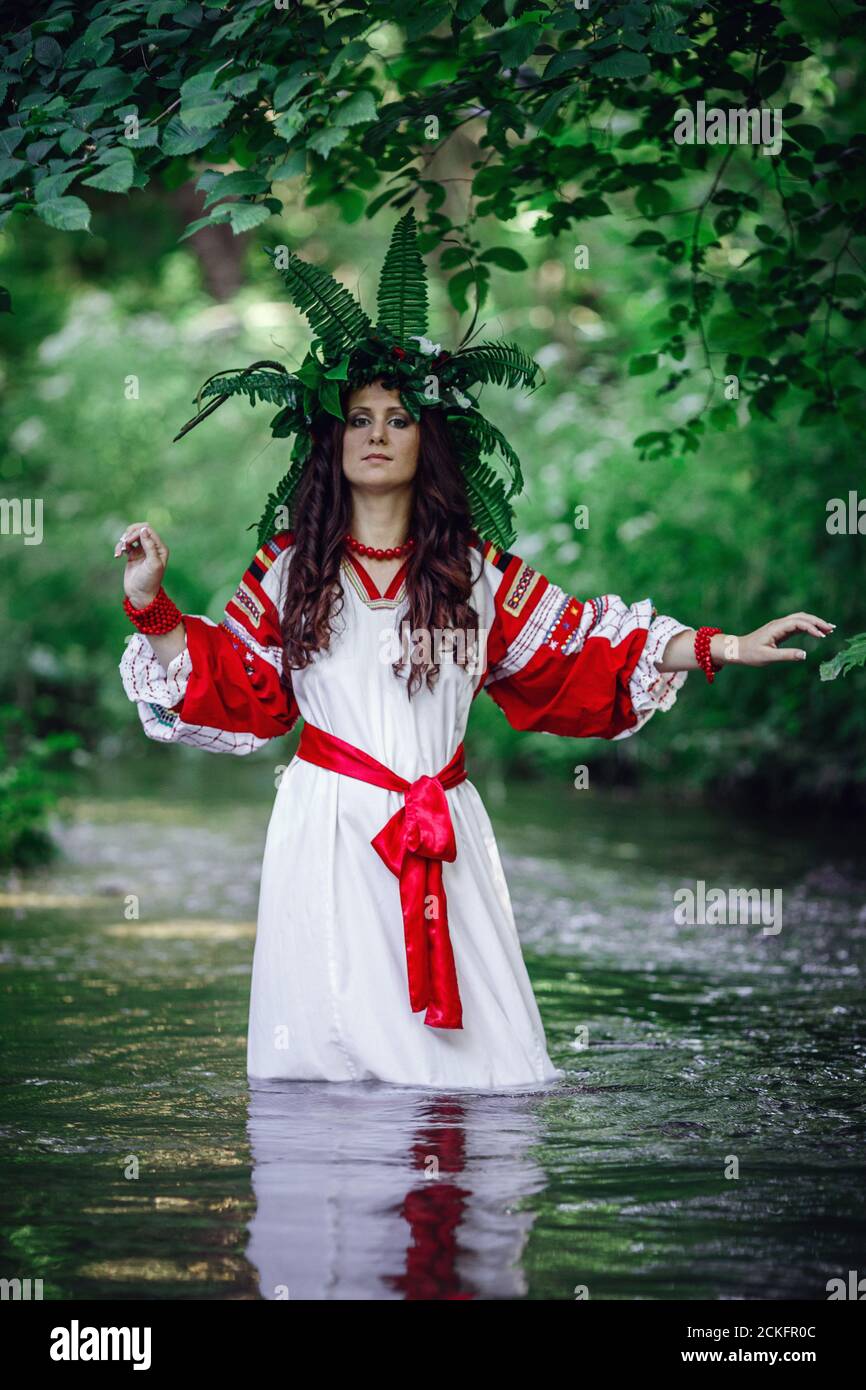 beautiful woman in wreath of wild flowers of flowers in sunny day ...