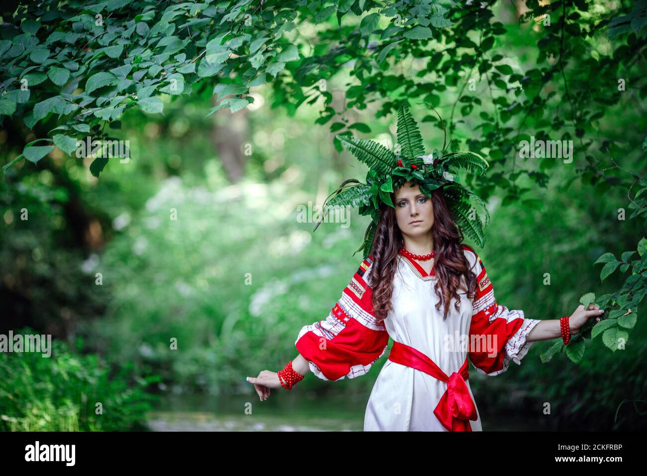 beautiful woman in wreath of wild flowers of flowers in sunny day ...