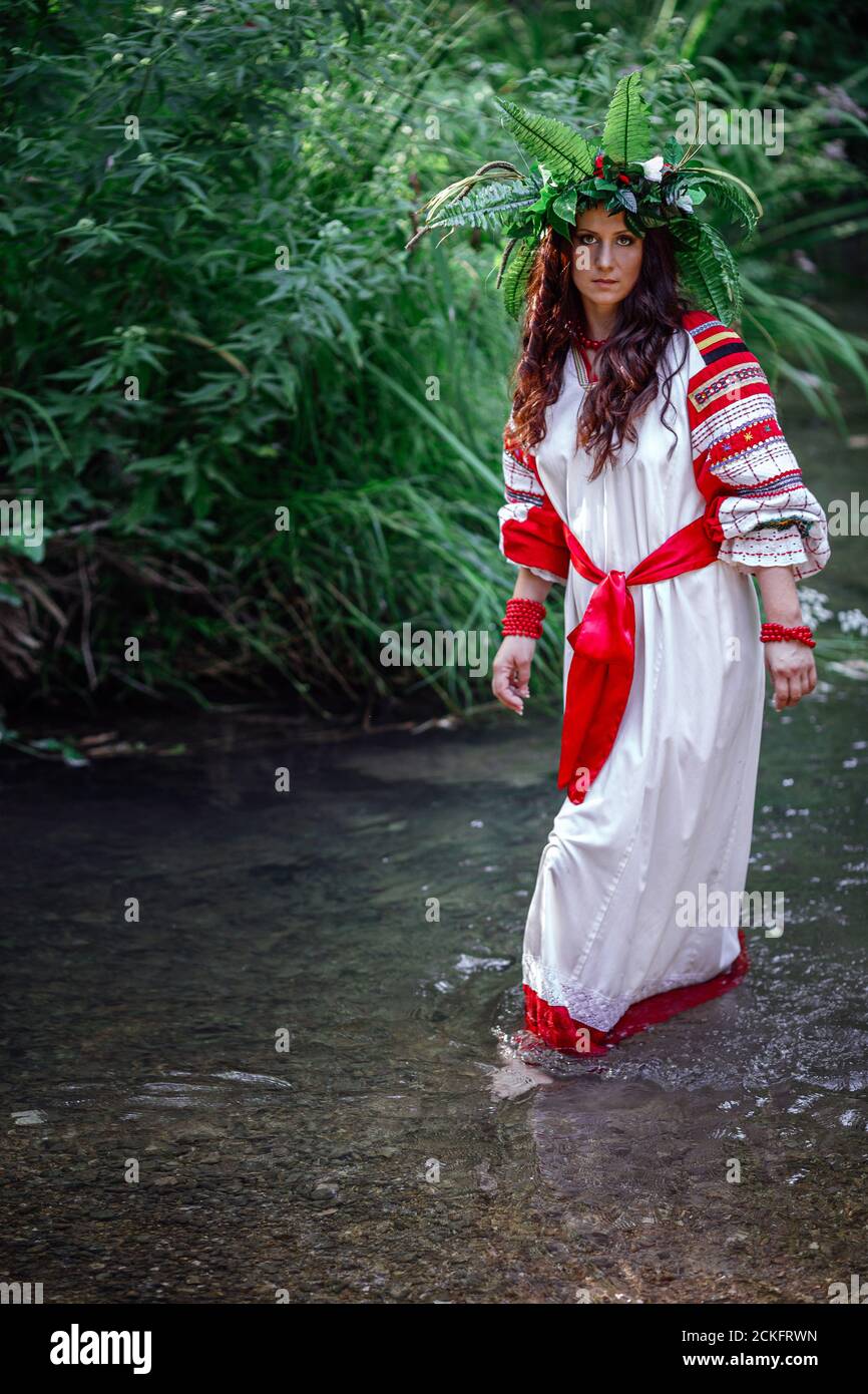 beautiful woman in wreath of wild flowers of flowers in sunny day ...