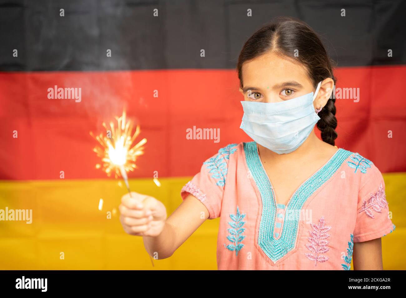 Young Girl Kid on medical mask holding Sparkler with german flag as ...