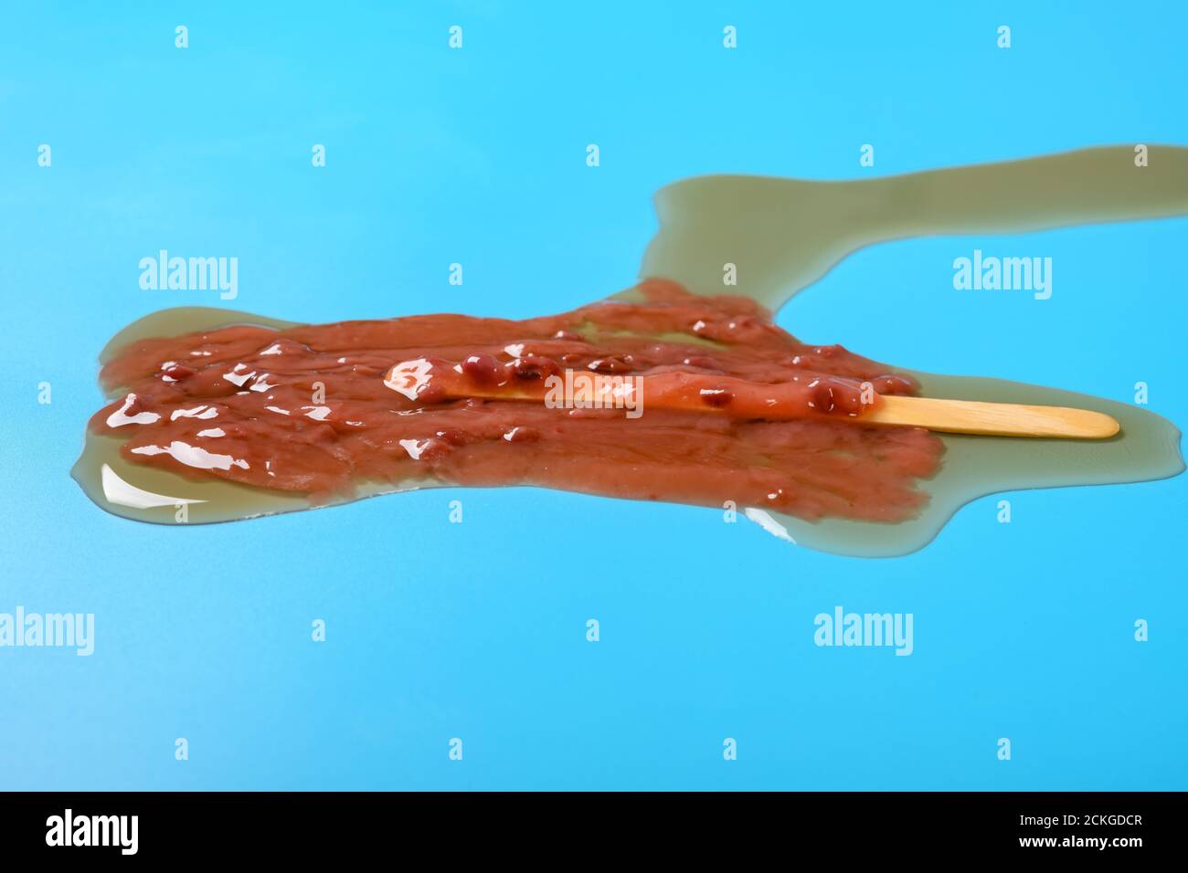 melted red bean popsicle on a blue background Stock Photo - Alamy