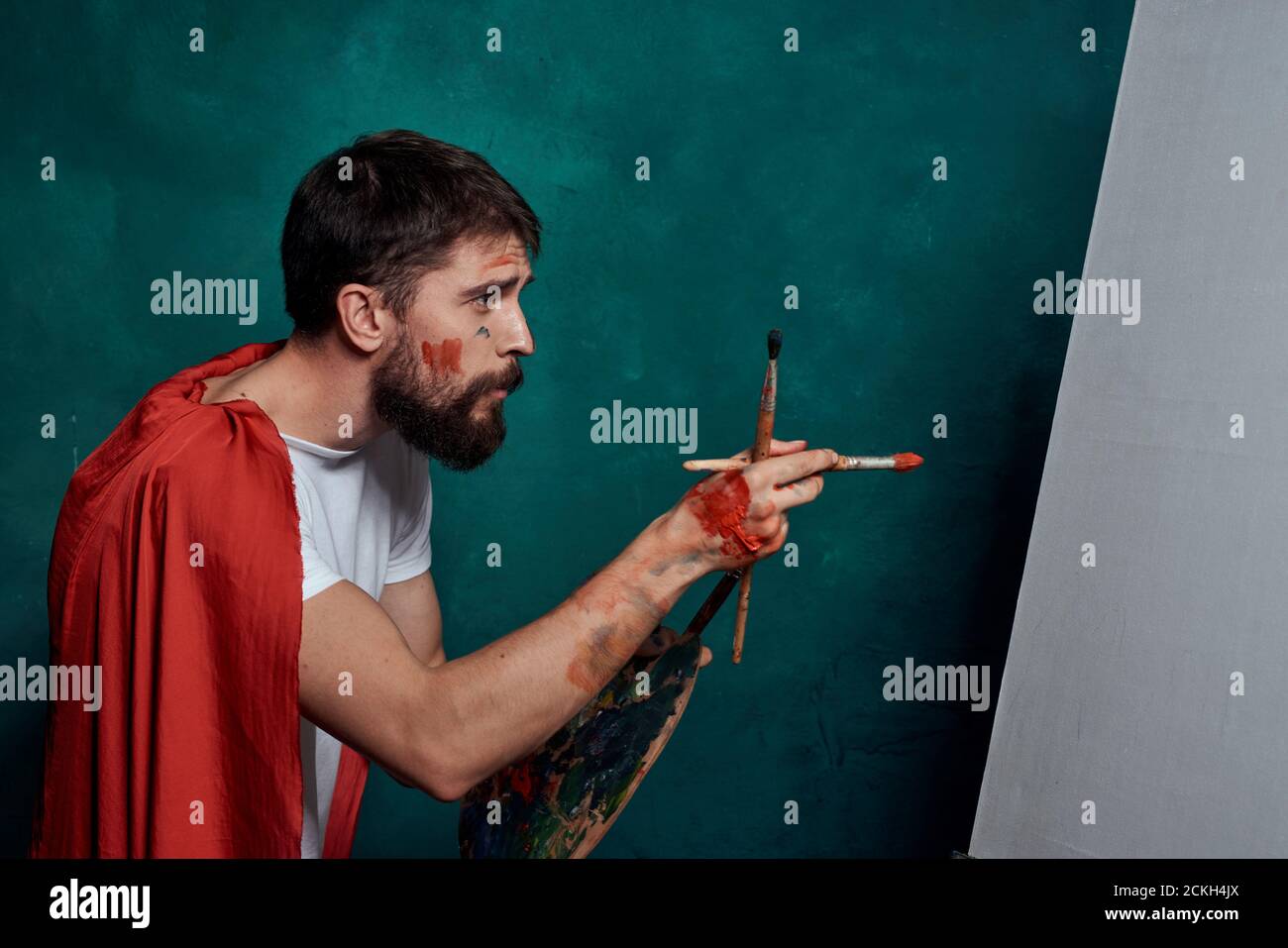 Male artist red cloak drawing easel art green background image Stock ...