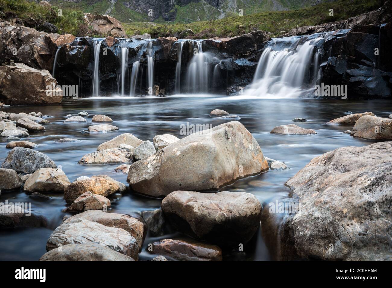 Fairy pools waterfalls surrounded by mountains during a cloudy day on ...