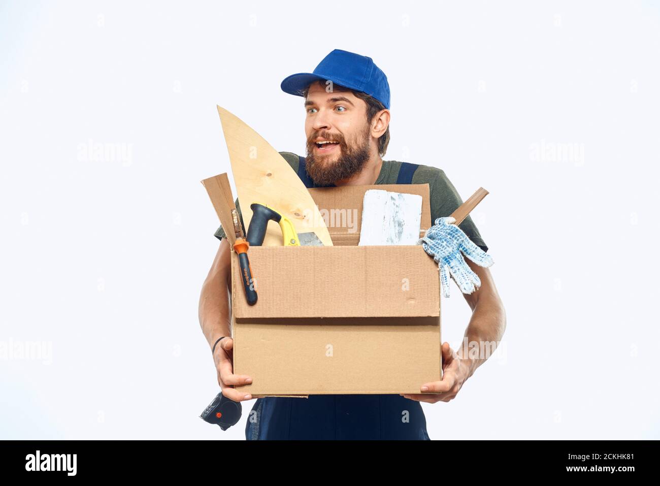 Worker man in uniform with a box in his hands tools delivery service ...