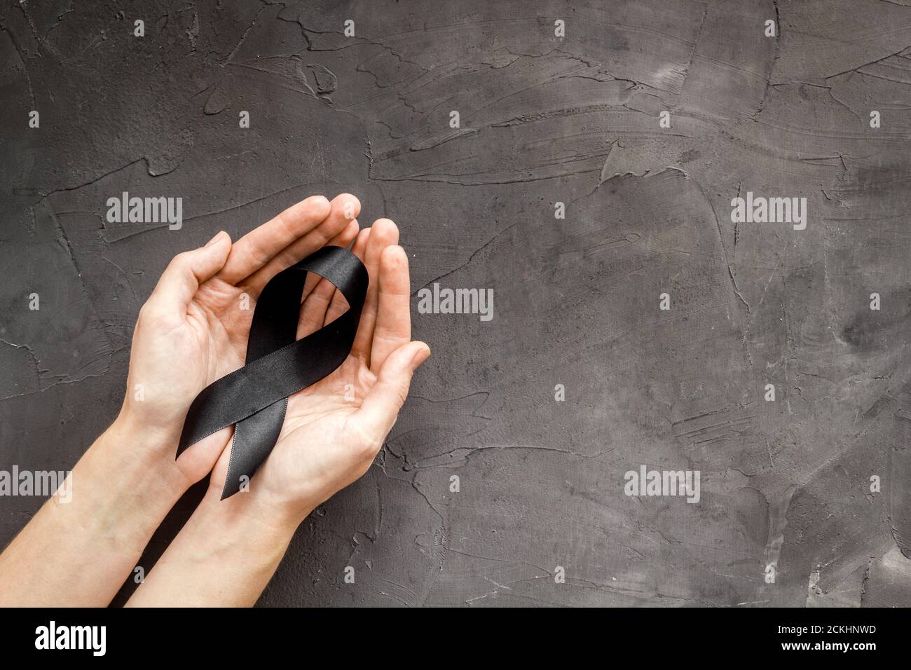 Hands holding black ribbon, top view. Funeral symbol Stock Photo - Alamy