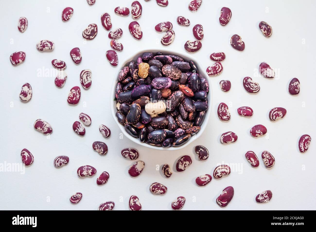 Raw red beans in a bowl and on white table surface Stock Photo - Alamy
