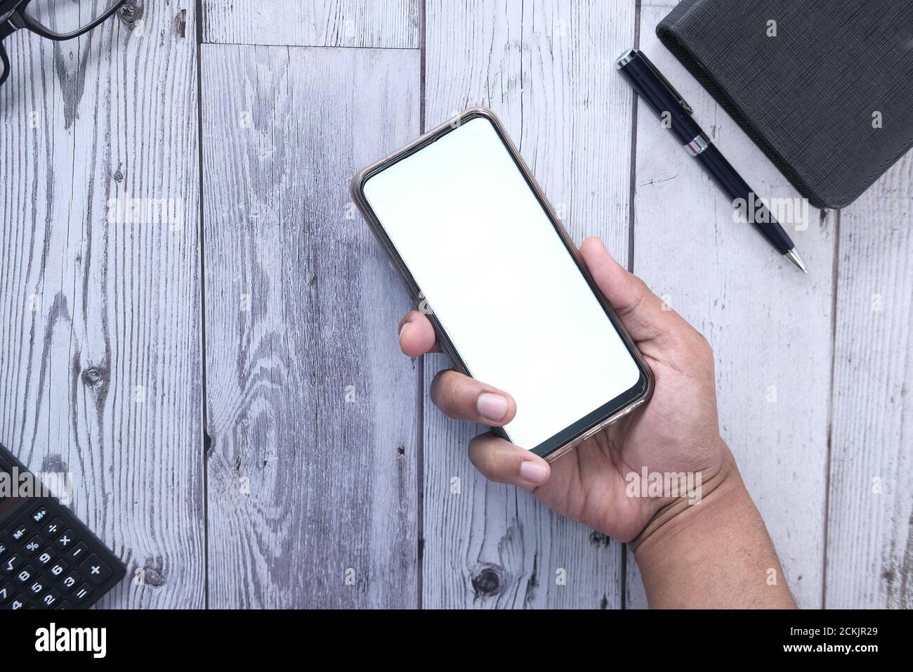 flat composition of hand holding smart phone on white background Stock ...