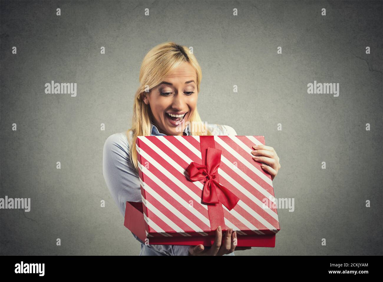 Closeup portrait young happy excited woman opening red gift box, very ...