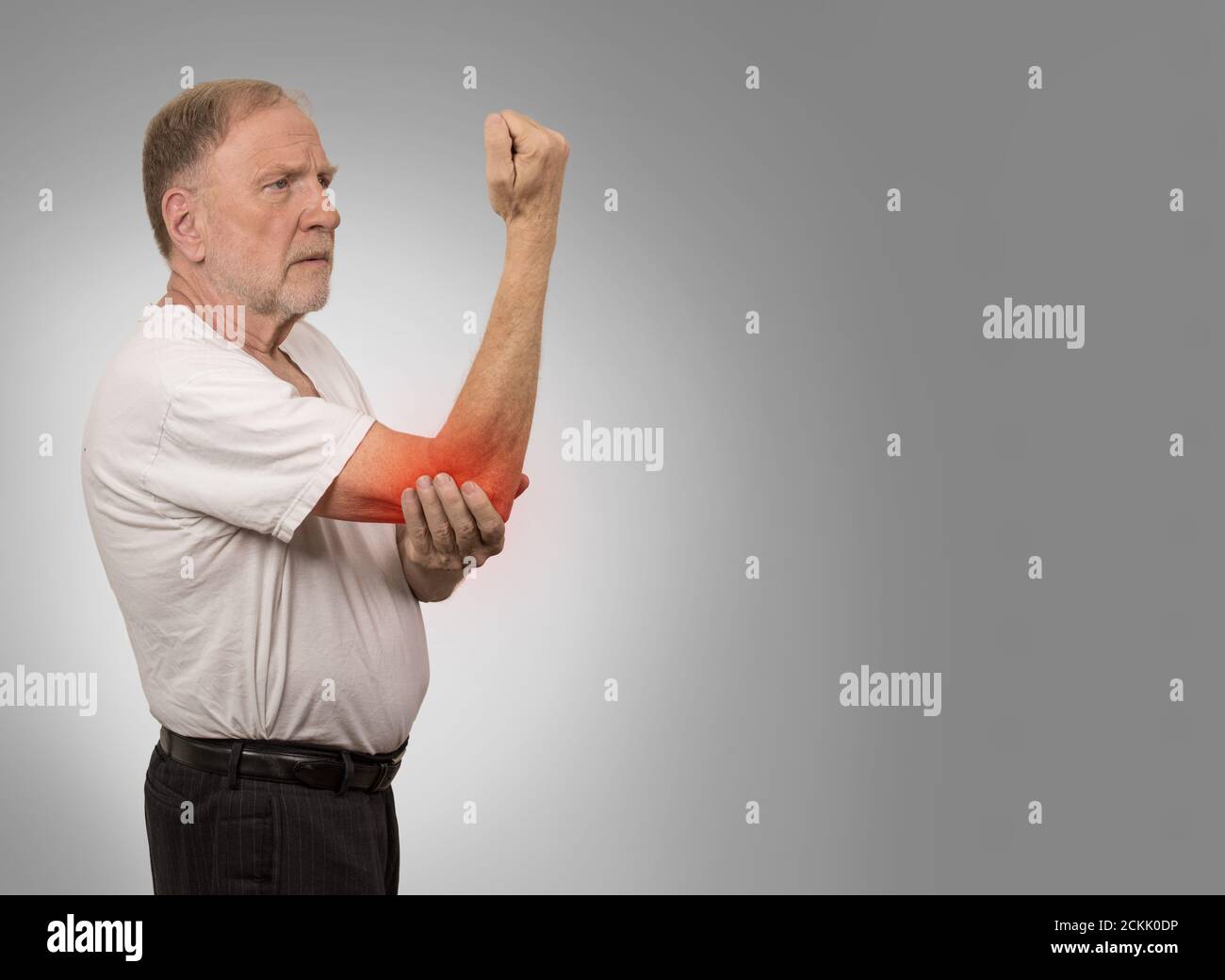 Closeup senior man with elbow inflammation colored in red suffering ...