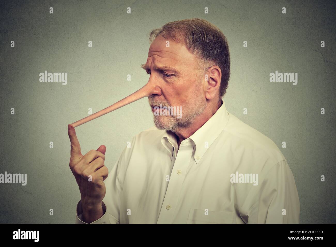 Sad man with long nose worried isolated on grey wall background. Liar ...