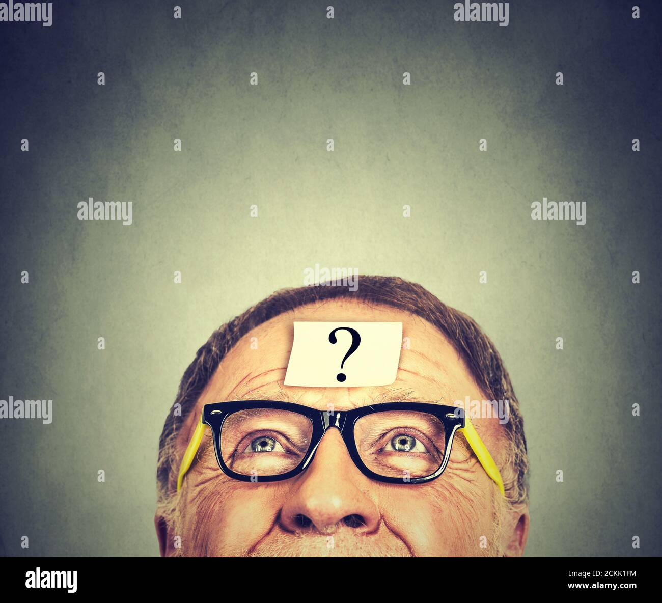 thinking man with question mark on gray wall background Stock Photo - Alamy