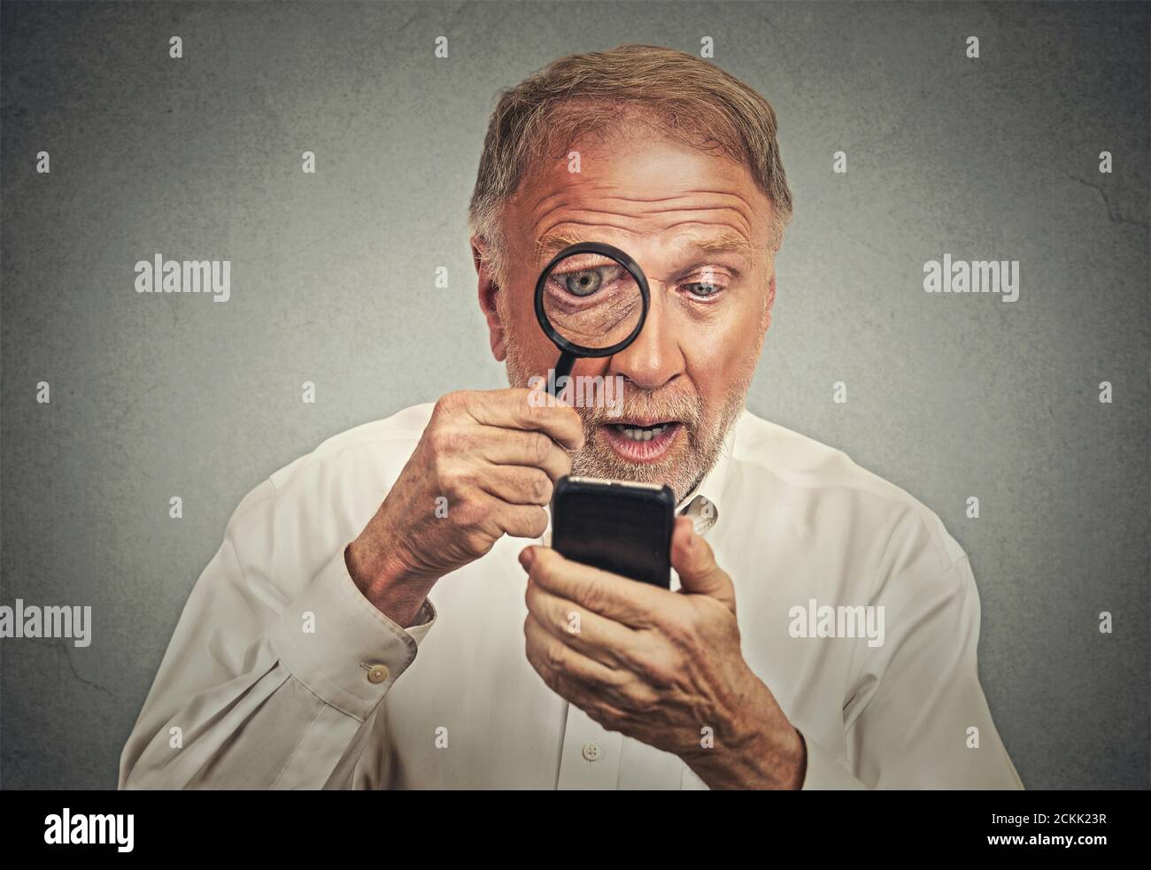 Curious. Portrait senior man investigator looking through magnifying ...