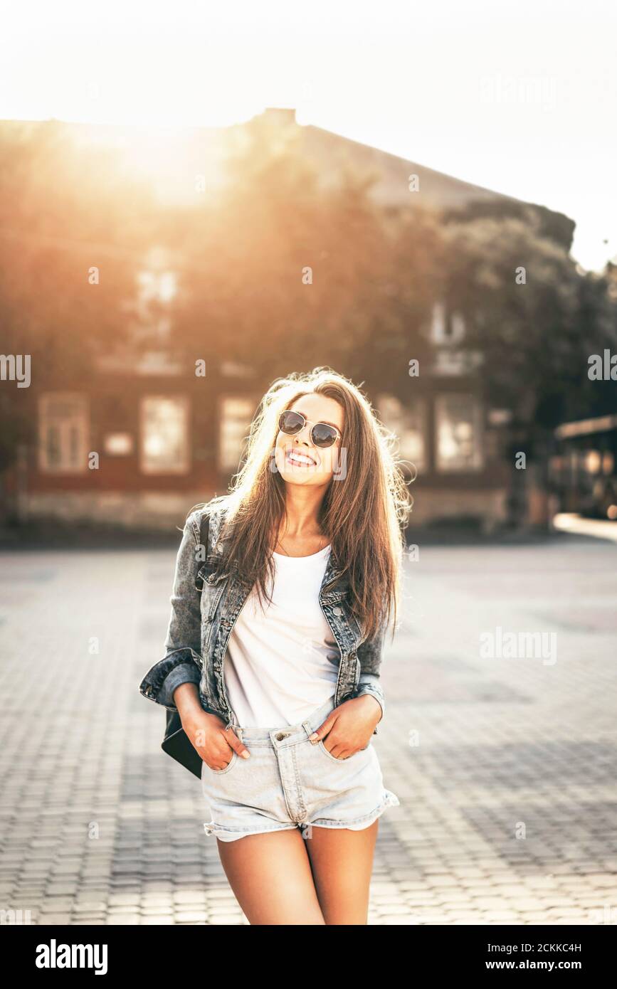 Pretty smiling brunette girl walking on the street Stock Photo - Alamy