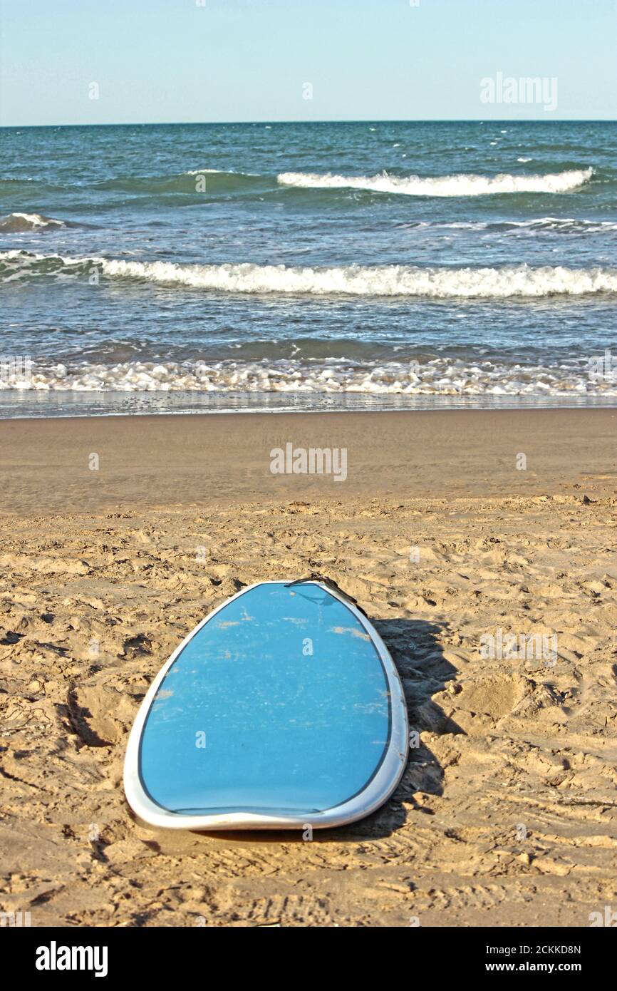 Vertical shot of a light blue surfboard on the beach Stock Photo - Alamy