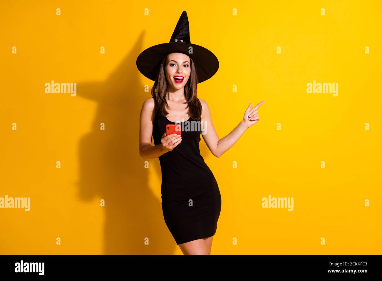 Photo excited spooky witch lady use smartphone point index finger ...