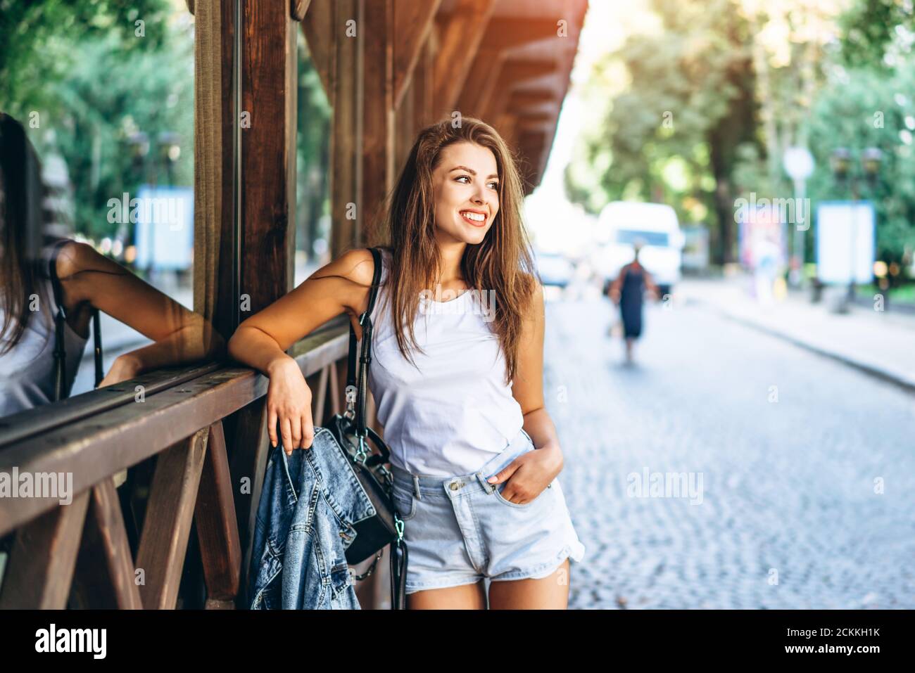 Pretty smiling brunette girl waking on the street Stock Photo - Alamy