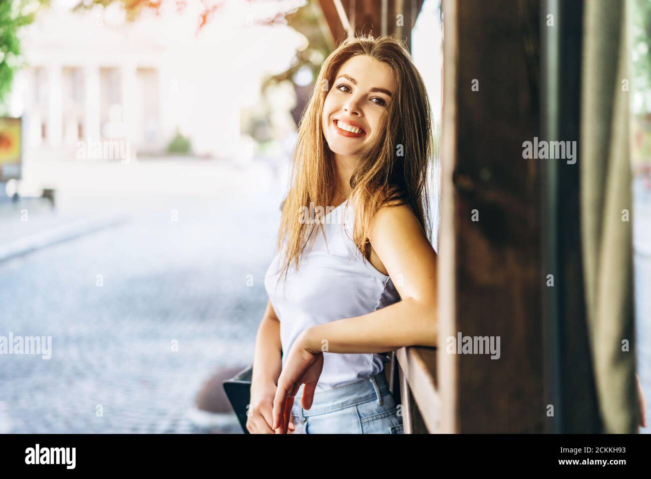 Pretty smiling brunette girl waking on the street Stock Photo - Alamy