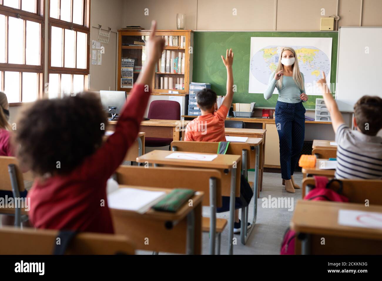 Kids raising hands classroom hi-res stock photography and images - Alamy
