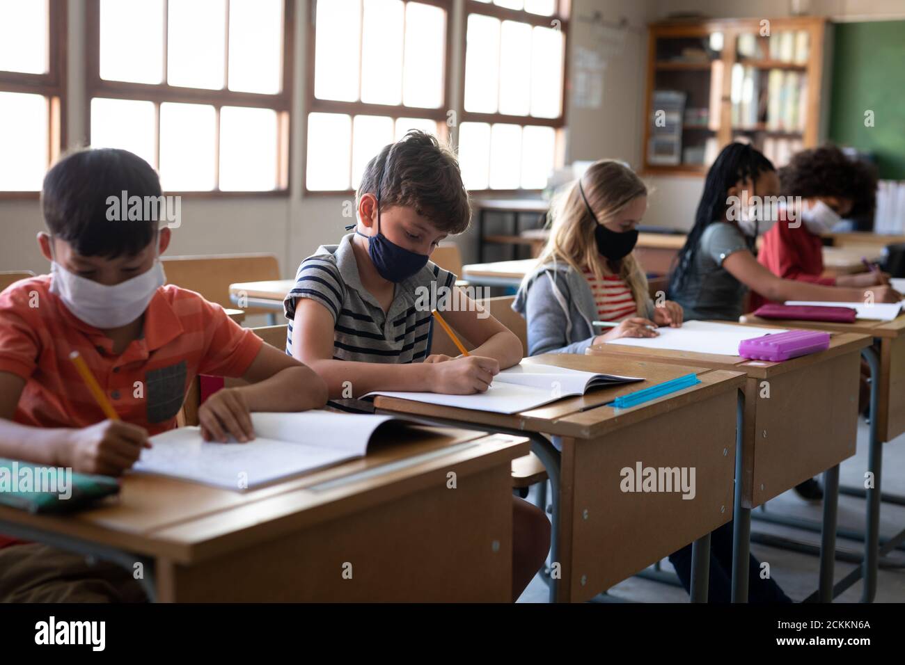 Group of kids wearing face masks studying in class at school Stock ...