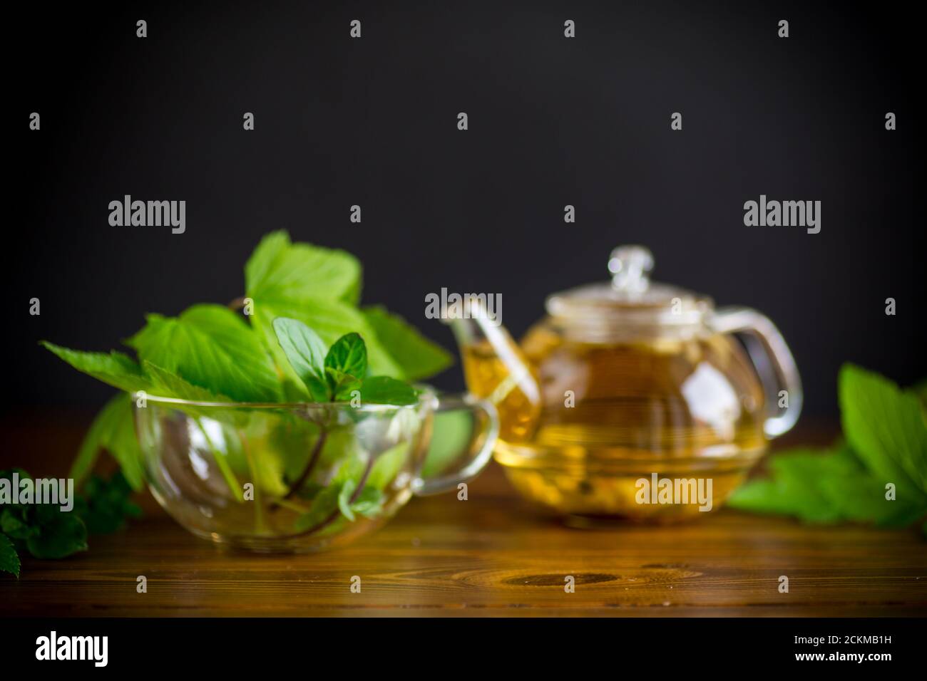 summer refreshing organic tea from currant leaves in a glass teapot ...