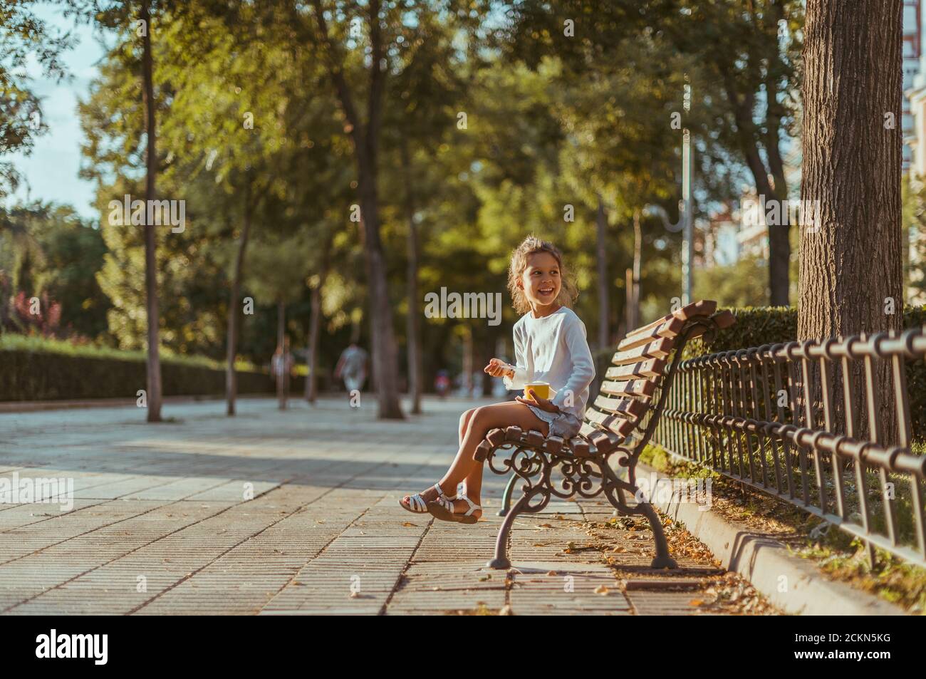 Child eating ice cream on a park bench Stock Photo - Alamy