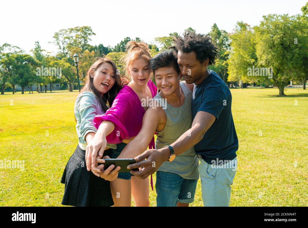 A group of friends having fun and taking selfies while enjoying a sunny ...