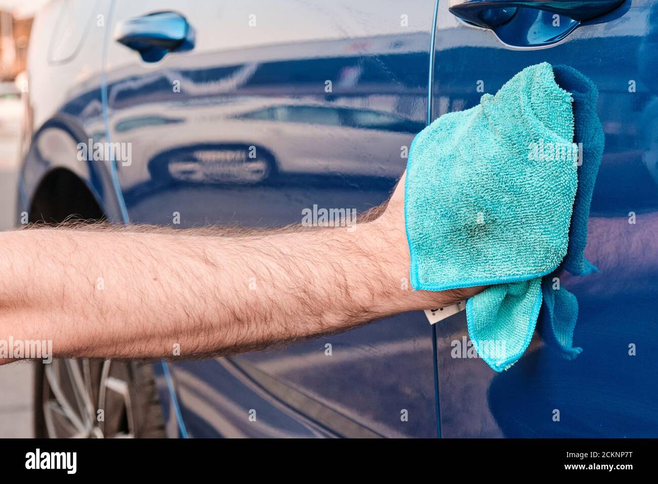 Cleaning or polishing of a blue car with microfiber cloth. Manual car ...