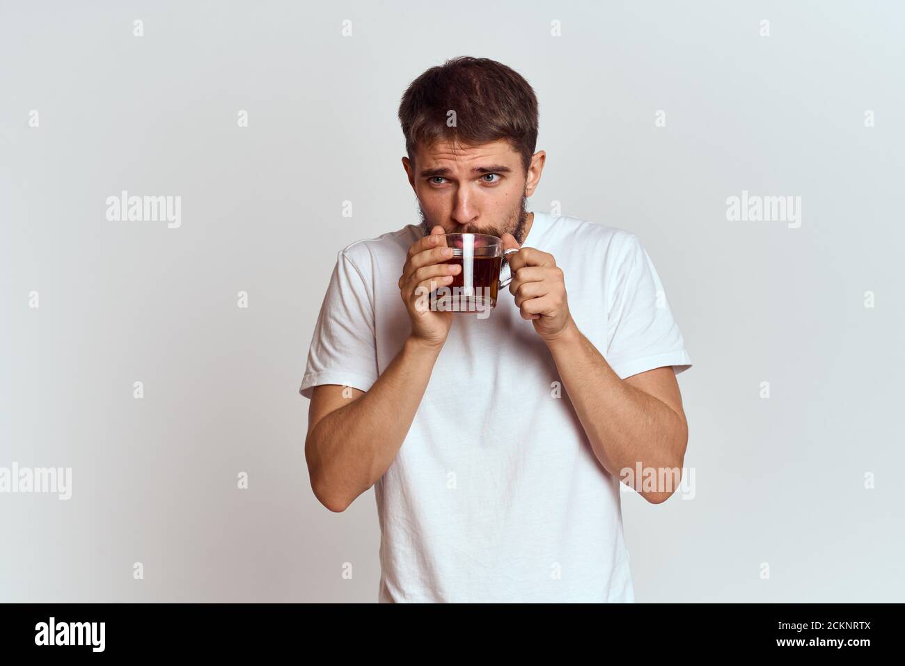 man with a cup of tea in a bag on a light background Hot drink cropped ...