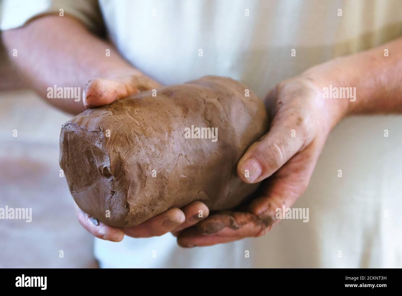 Male hand hold piece of clay Stock Photo - Alamy