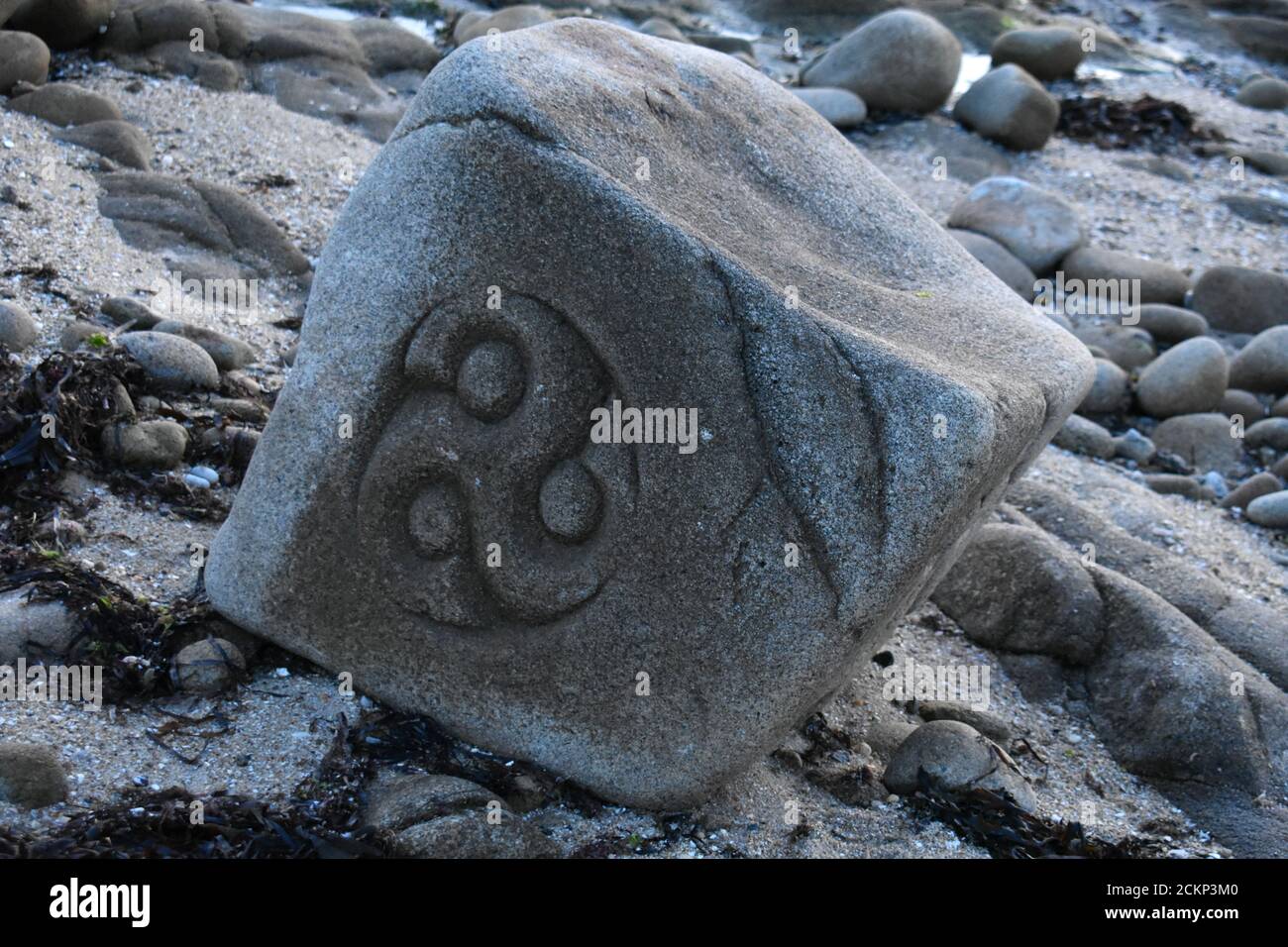 close up of Ancient cubed stone with unusual carvings washed up on ...