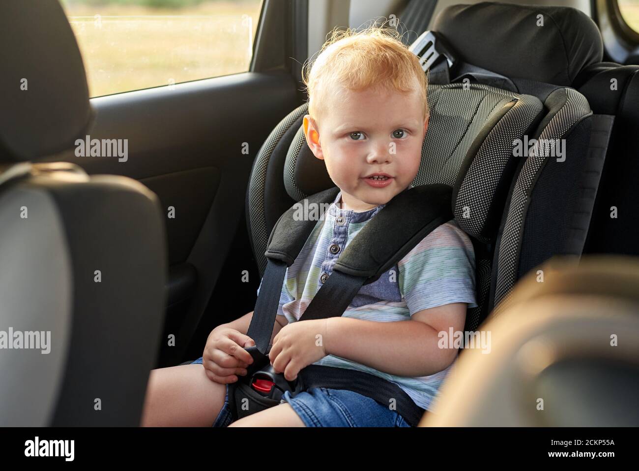 Happy little boy sits in a car seat. Child safety in the car Stock ...