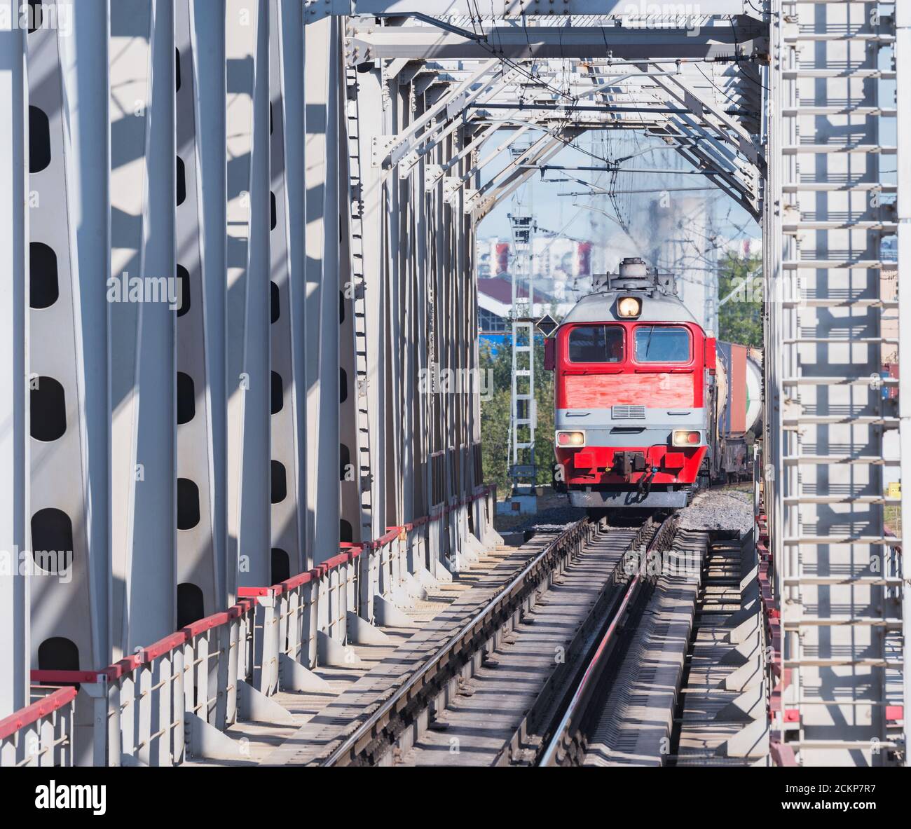 Diesel freight train moves through the bridge Stock Photo - Alamy