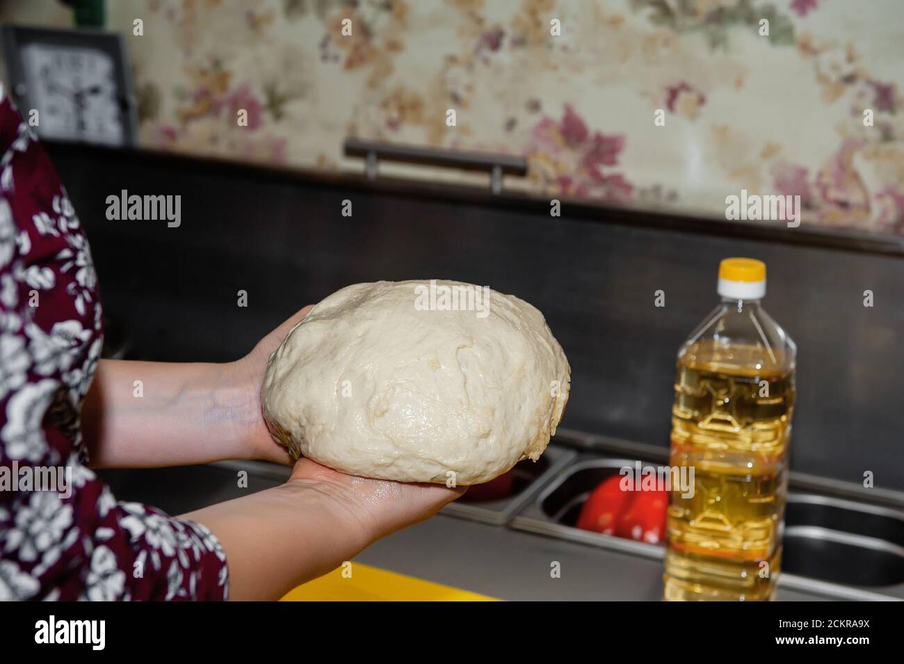 cook holds a tender dough in his hands. The dough is ready for baking ...