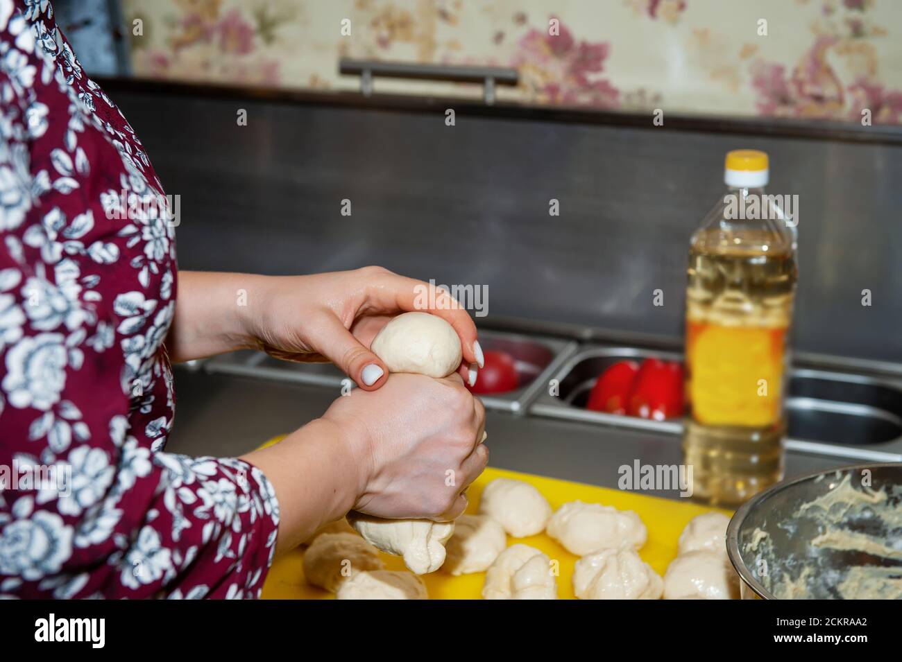 cook's hands divide and form the dough pieces into portions. dough is ...