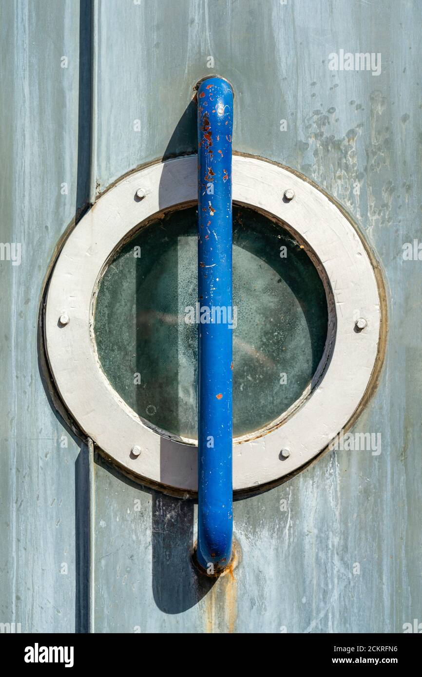Modern blue door handle with a round window looking like a scuttle ...