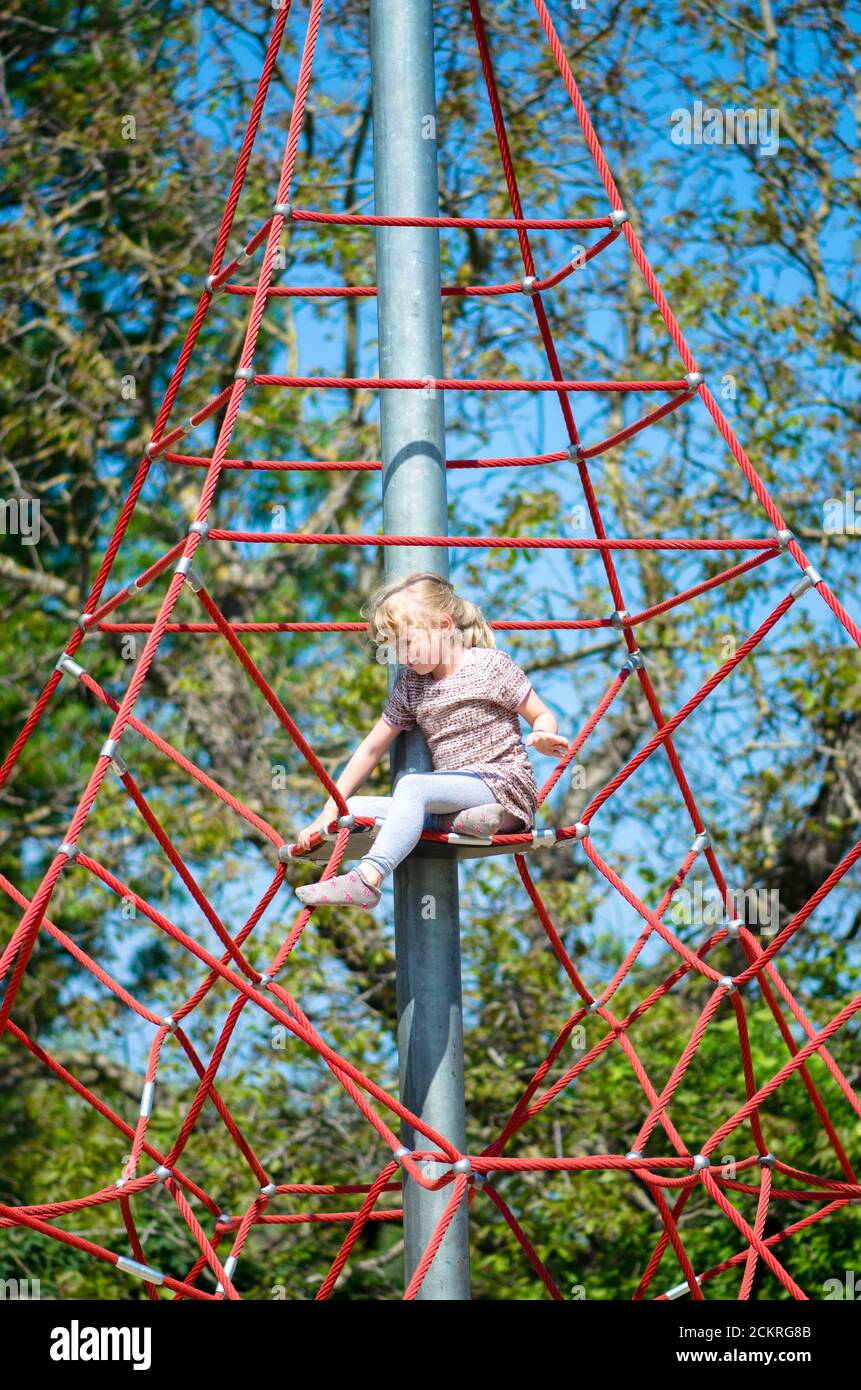 girl climbing up on a playground Stock Photo - Alamy