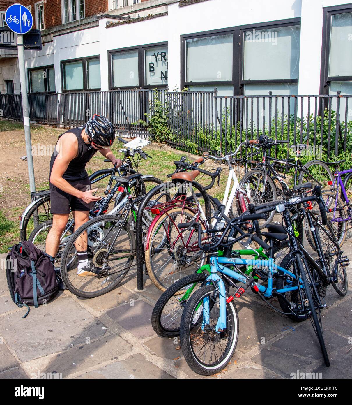Man locking bicycle hi-res stock photography and images - Alamy