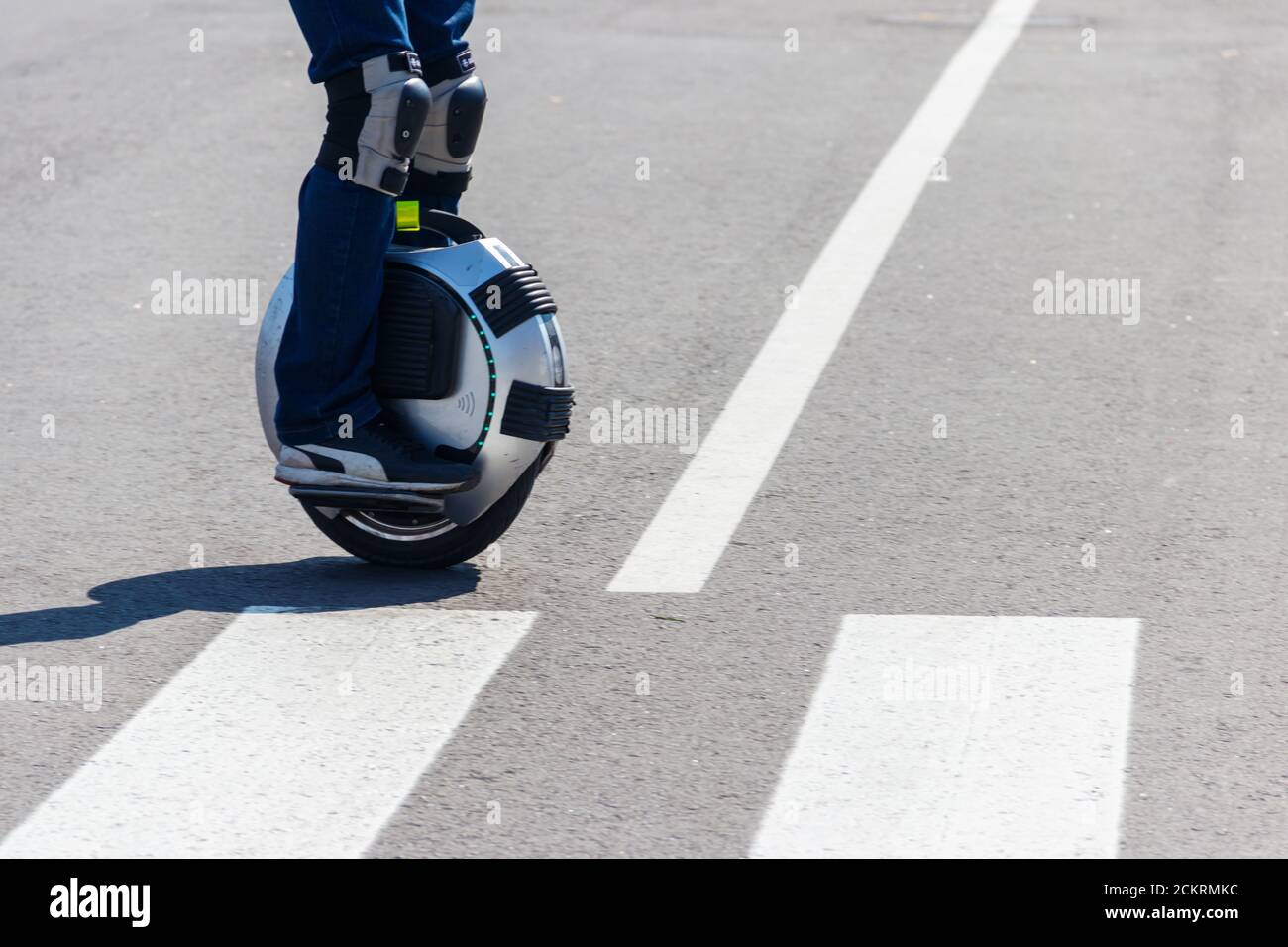 Electric unicycle. Man rides on mono wheel on zebra crossing Stock ...