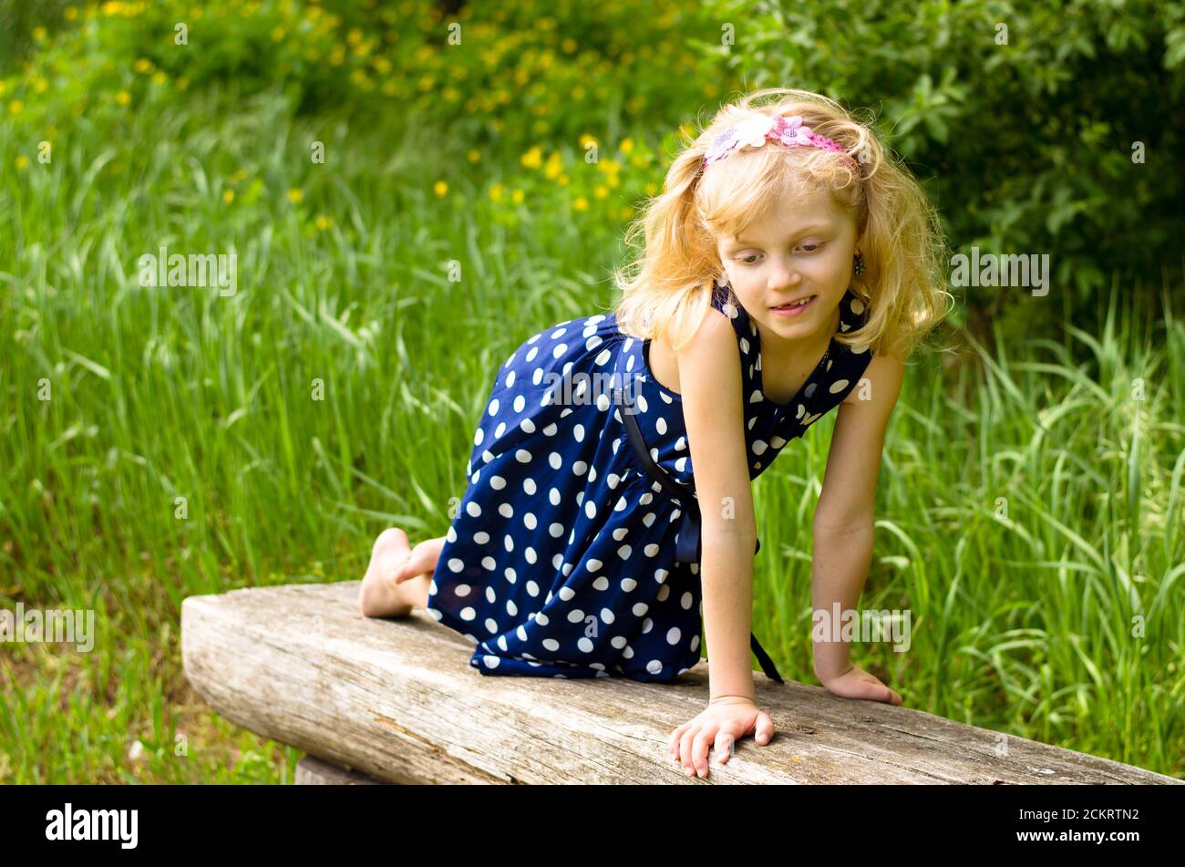 beautiful mischievous blond girl in bench Stock Photo - Alamy
