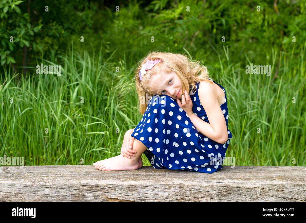 sad blond girl sitting in bench Stock Photo - Alamy