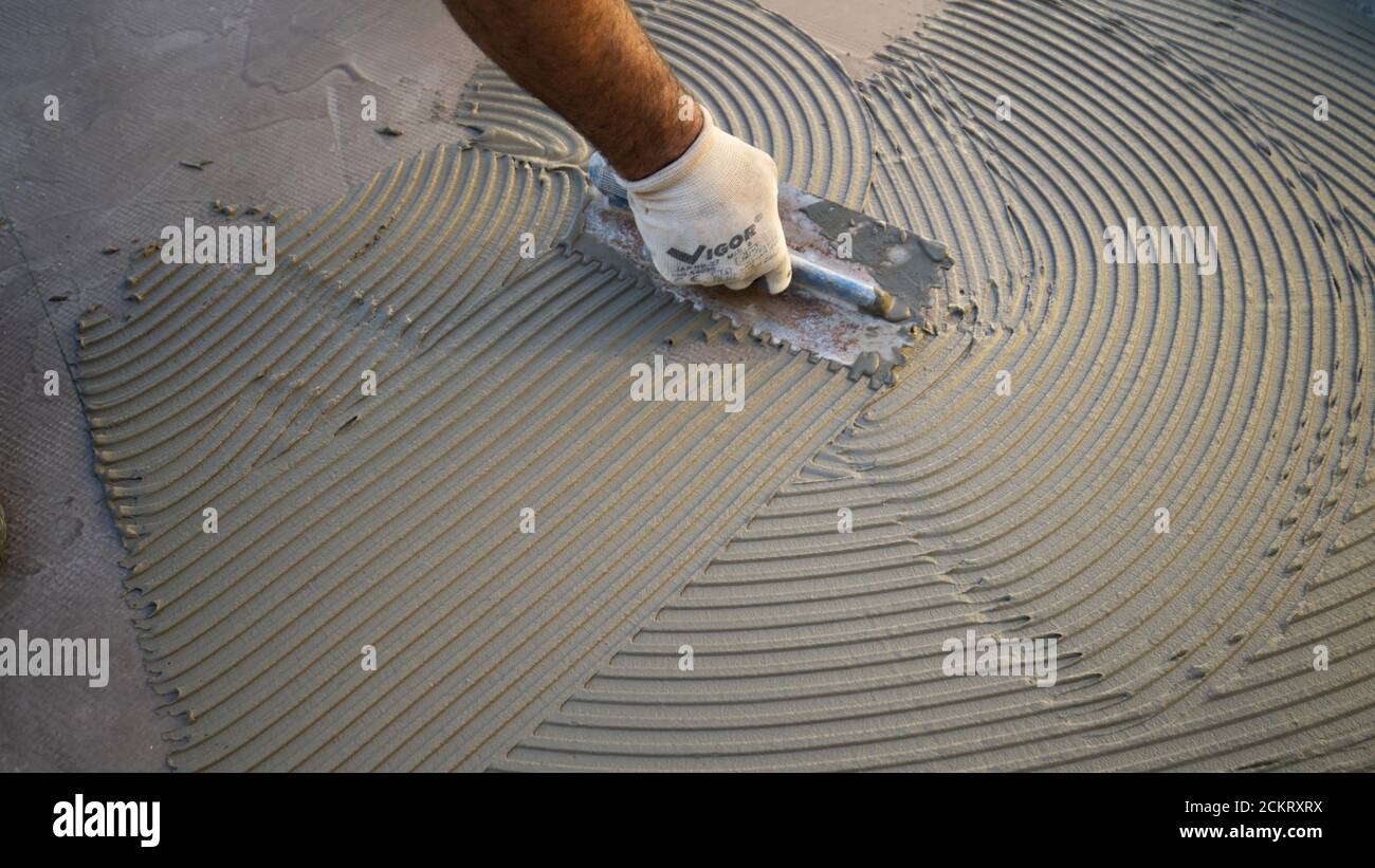 cementitious adhesive applied to the floor ready to receive the ceramic ...