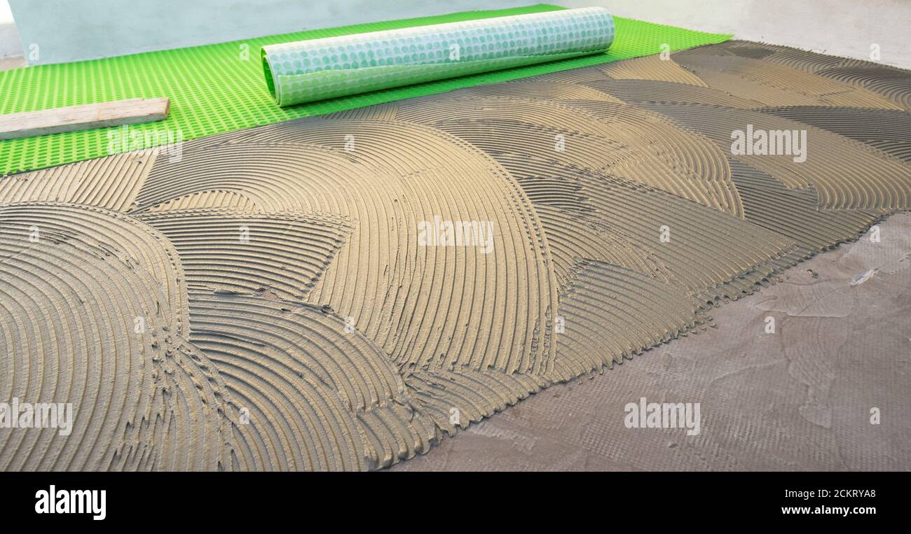 cementitious adhesive applied to the floor ready to receive the ceramic ...