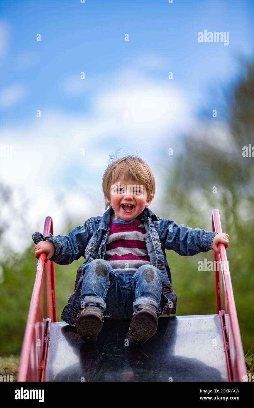 happy young boy on a slide Stock Photo - Alamy