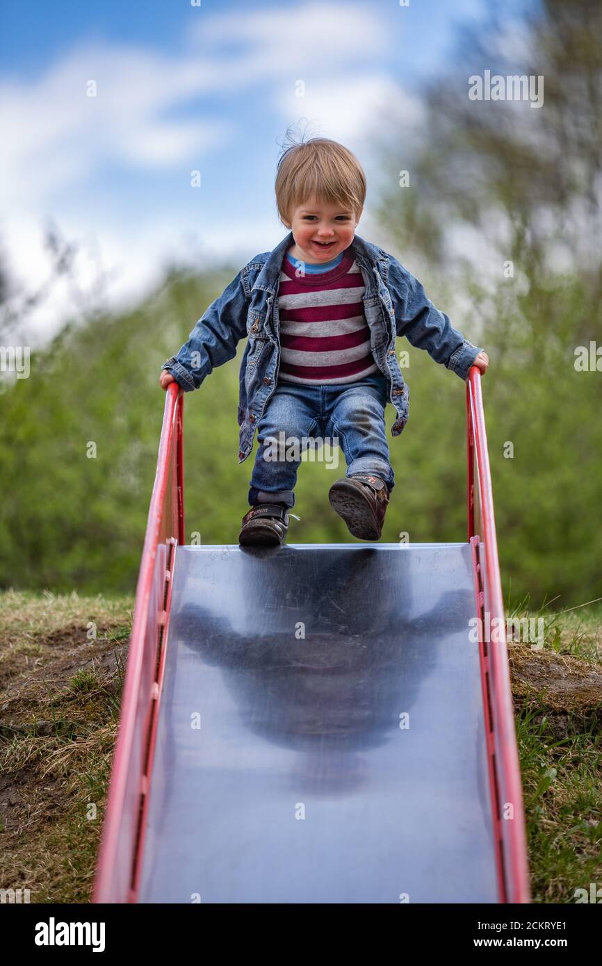 happy young boy having fun on a slide Stock Photo - Alamy