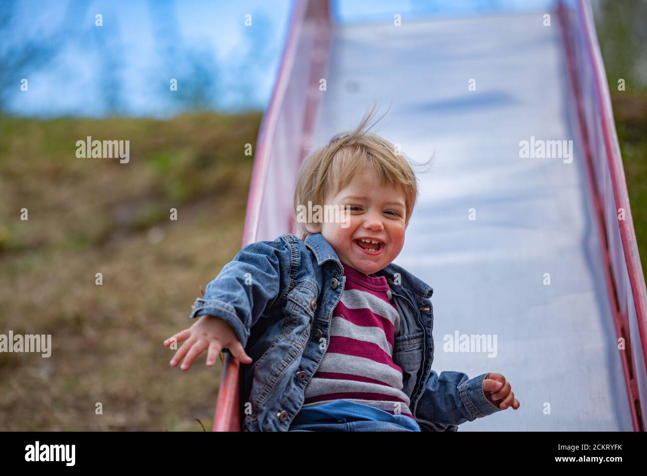 Boy sliding down playground slide hi-res stock photography and images ...