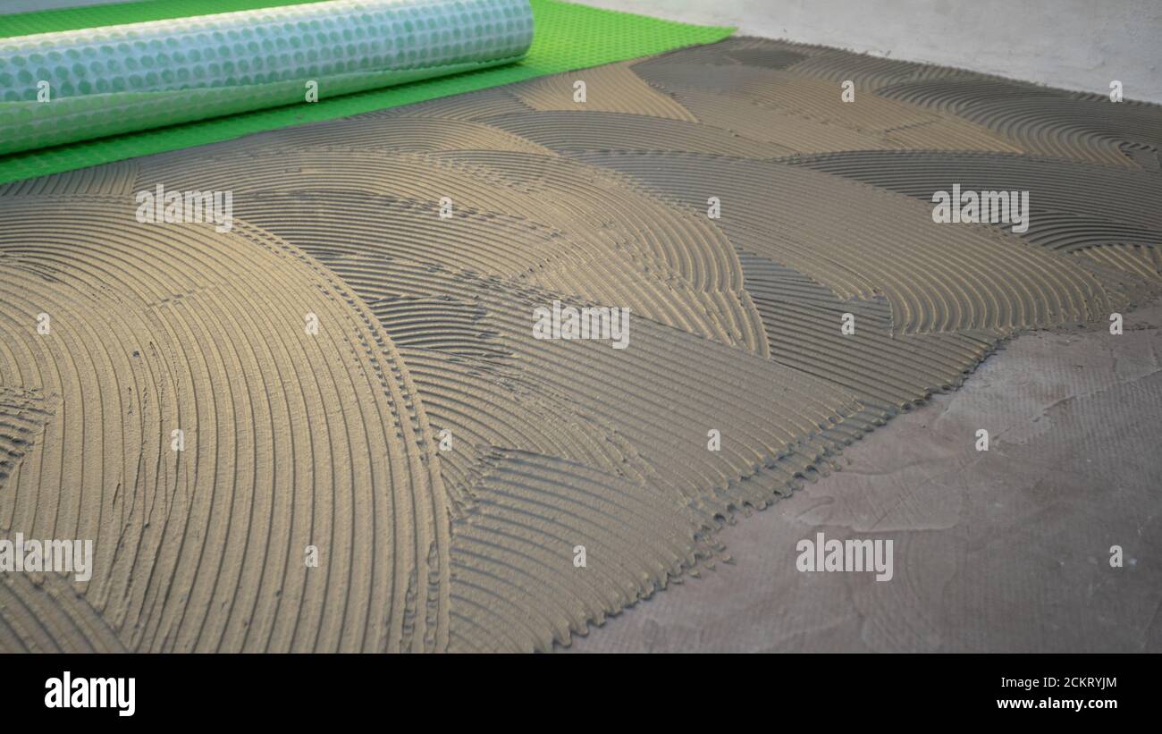 cementitious adhesive applied to the floor ready to receive the ceramic ...