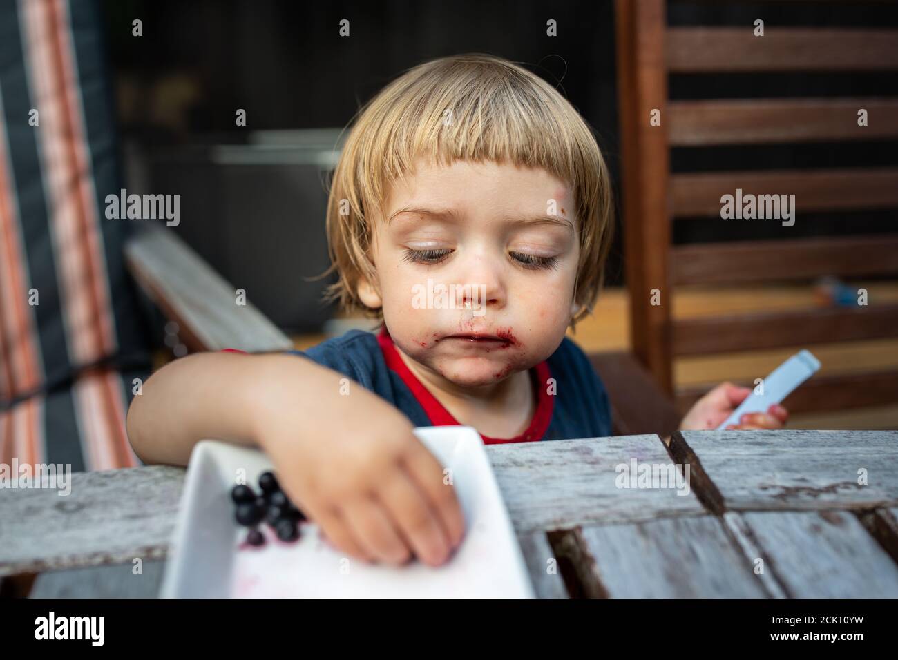Young boy eating blueberries Stock Photo - Alamy