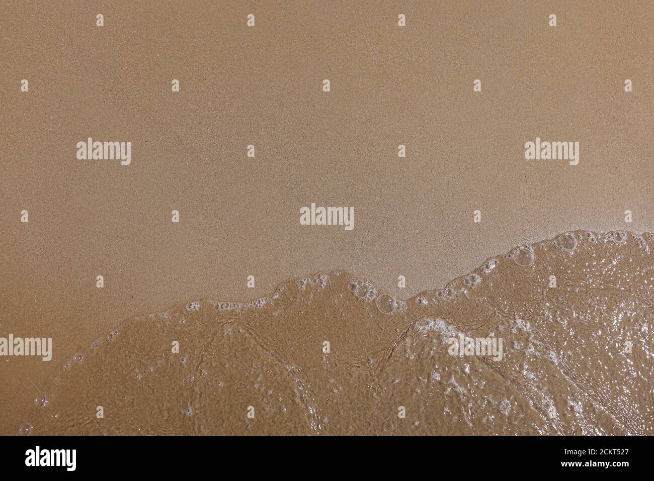 Smooth fine sand and clear water with bubbles Stock Photo - Alamy