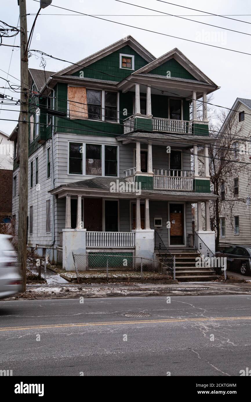 Decrepit unoccupied three-story apartment house with broken and nailed ...